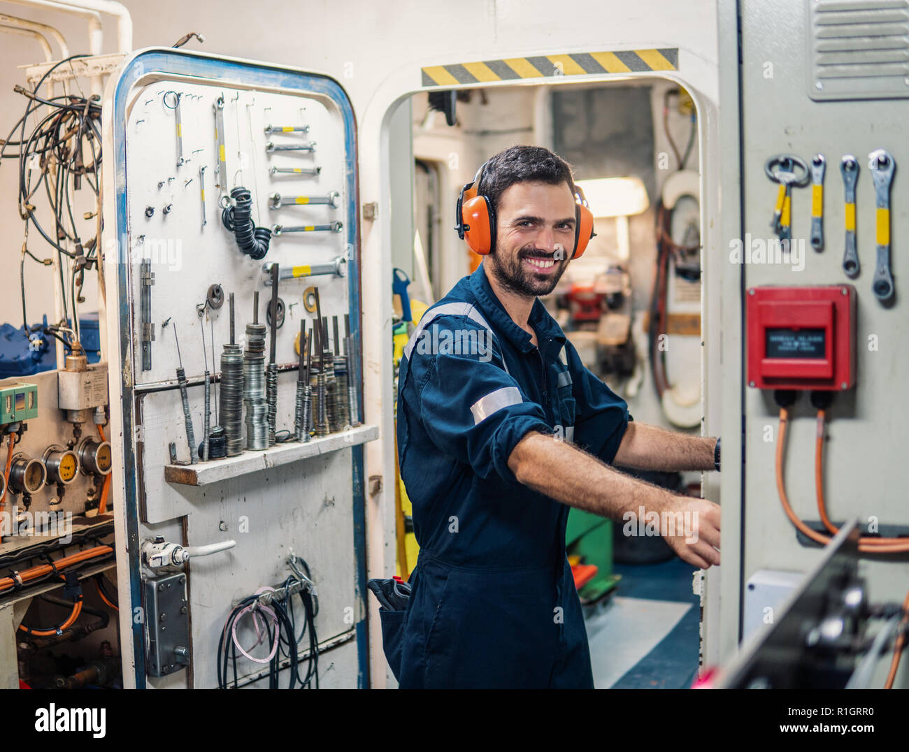 Marine engineer officer working in engine room Stock Photo - Alamy