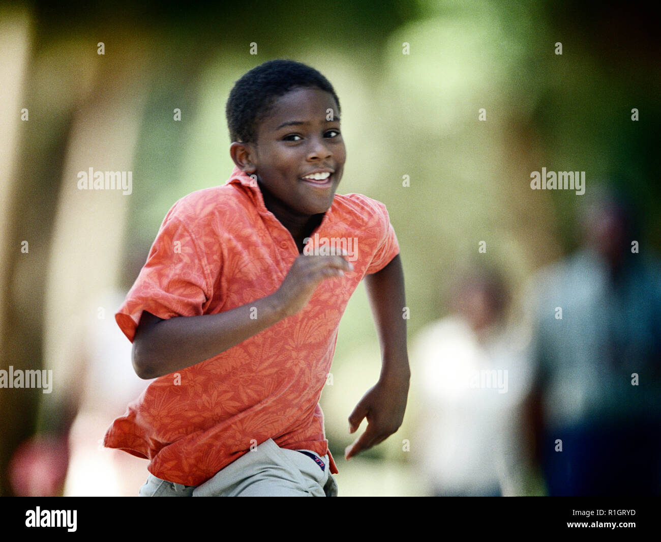 Front view a young boy running and smiling Stock Photo - Alamy