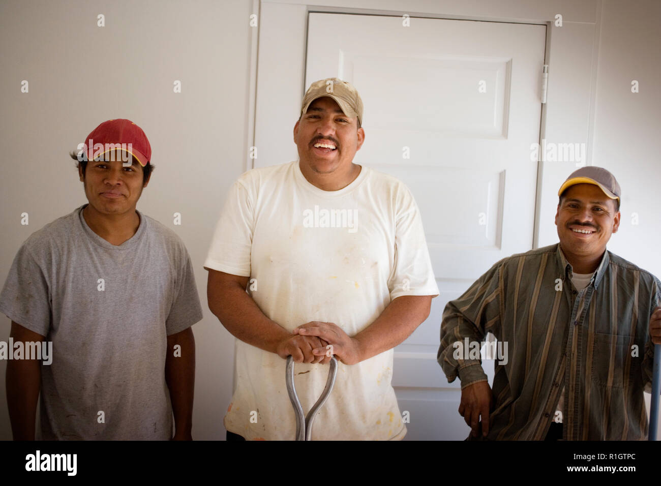 Portrait of three male builders inside a house Stock Photo - Alamy