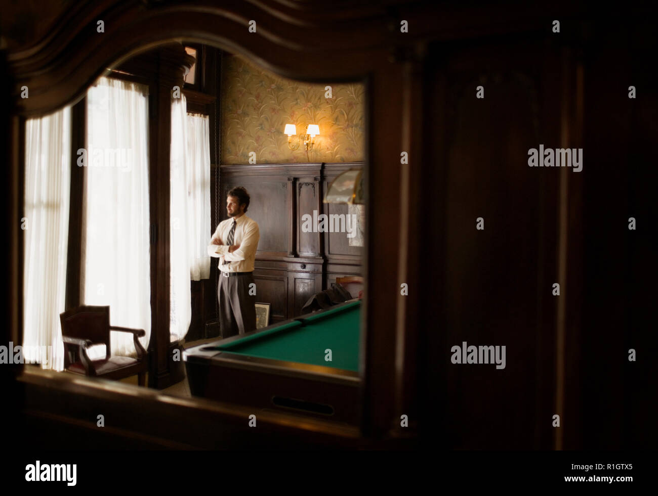 Side view of a man standing beside a pool table Stock Photo - Alamy