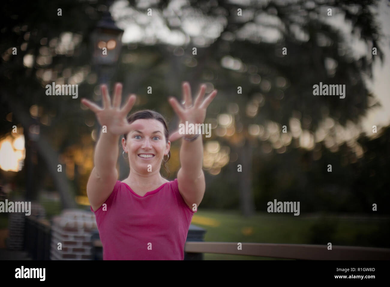 Portrait of a mid-adult woman with her arms reaching out and showing ...
