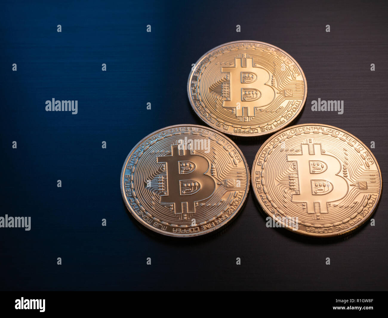 three btc gold bitcoins on metal background. low key shot for virtual ...