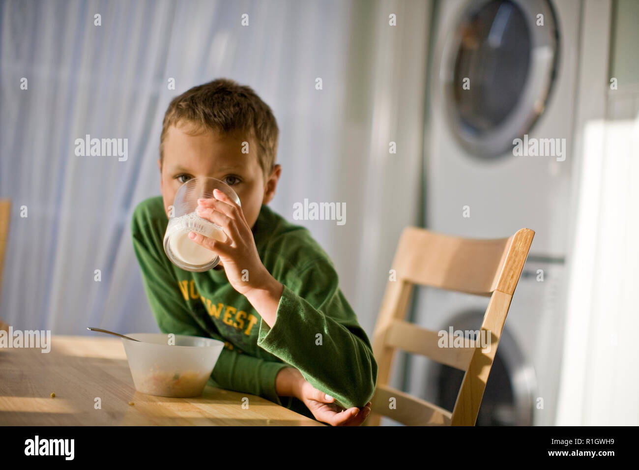 Boy drinking milk at the dining table Stock Photo - Alamy