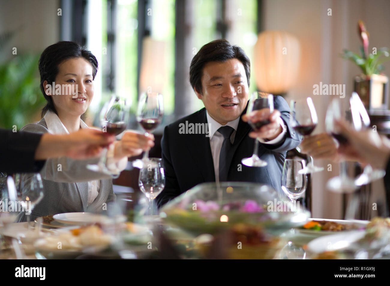 Business colleagues making a toast with glasses of red wine while ...