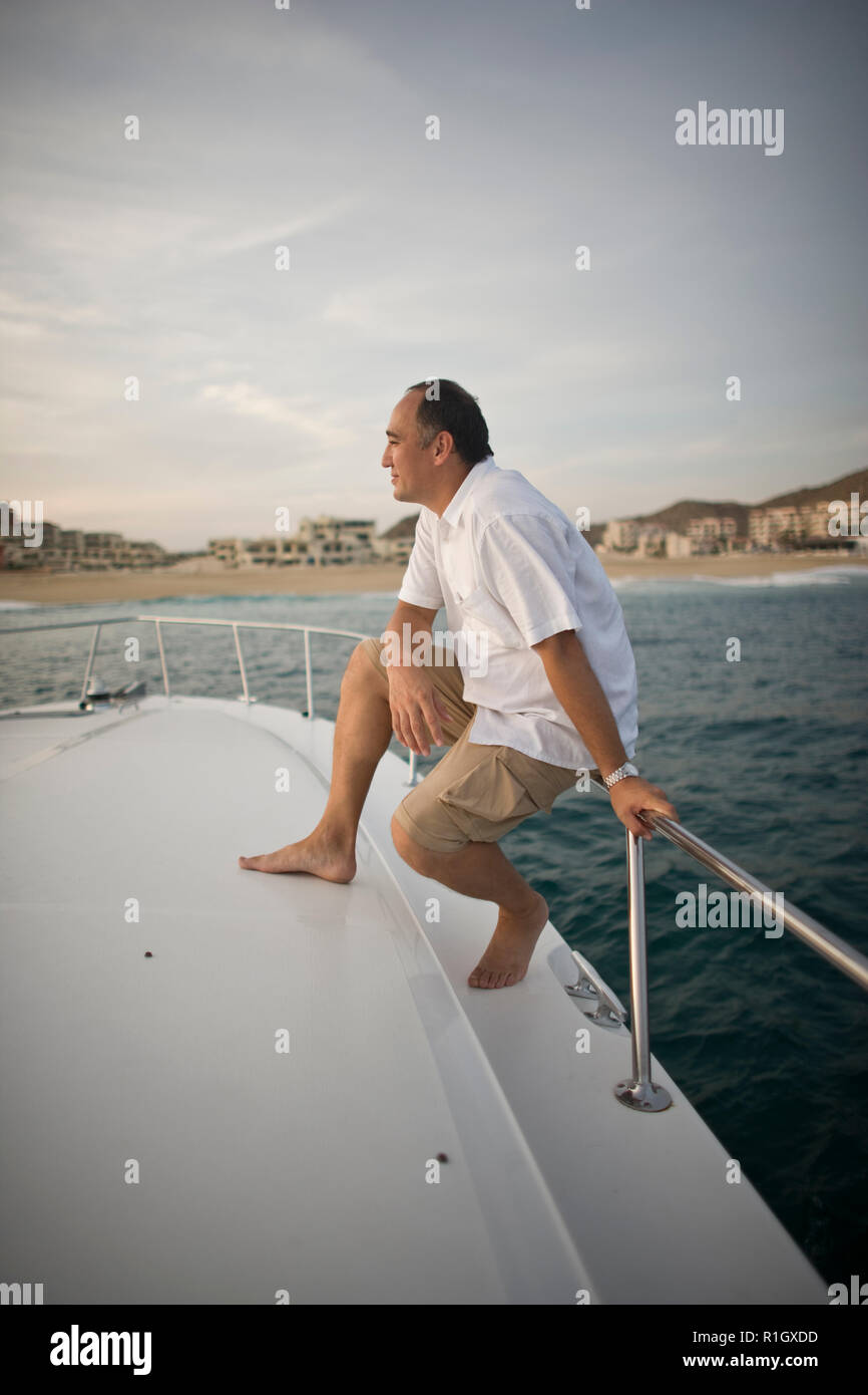 Mid-adult man leaning against the railing of a boat in the ocean Stock ...
