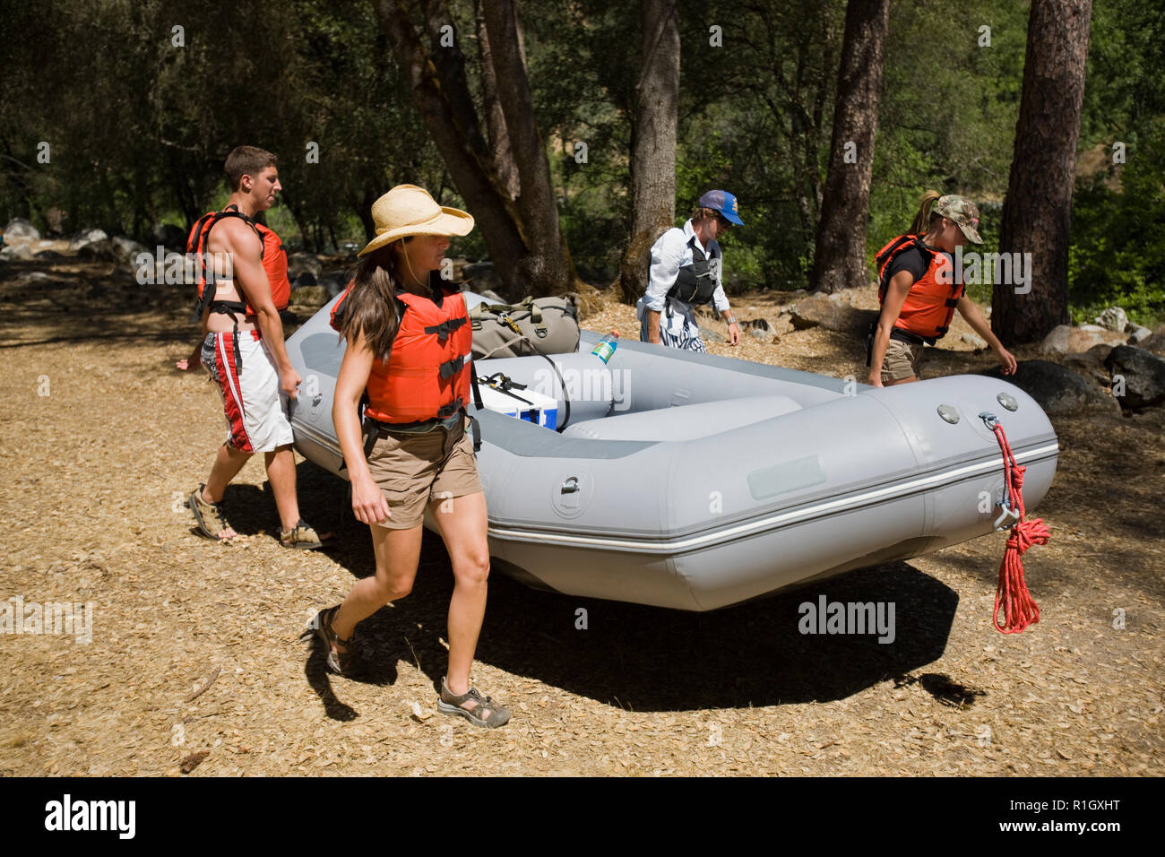 Group of people carrying a raft Stock Photo - Alamy
