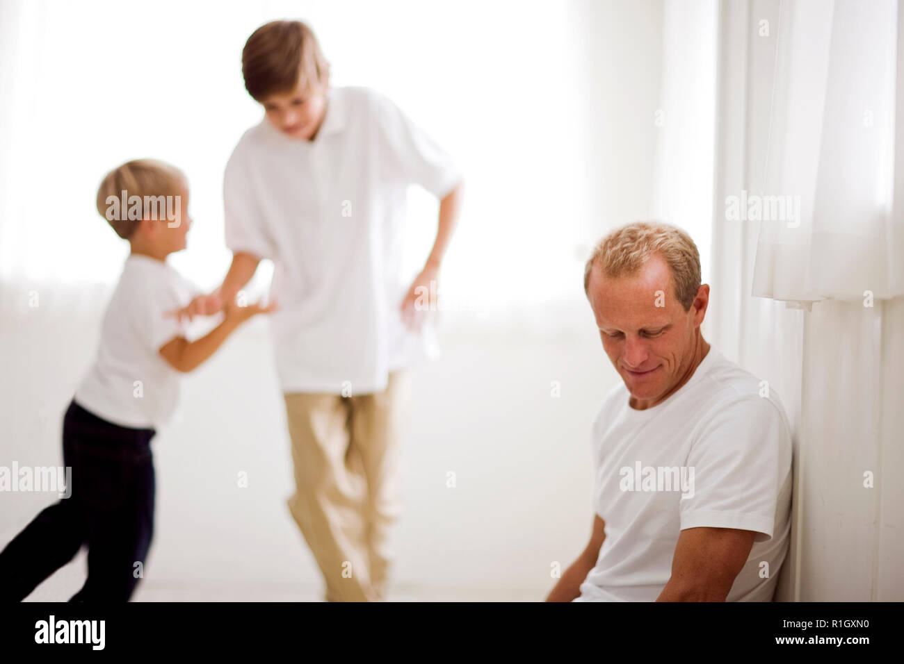 Father playing with his two young sons inside his home Stock Photo - Alamy