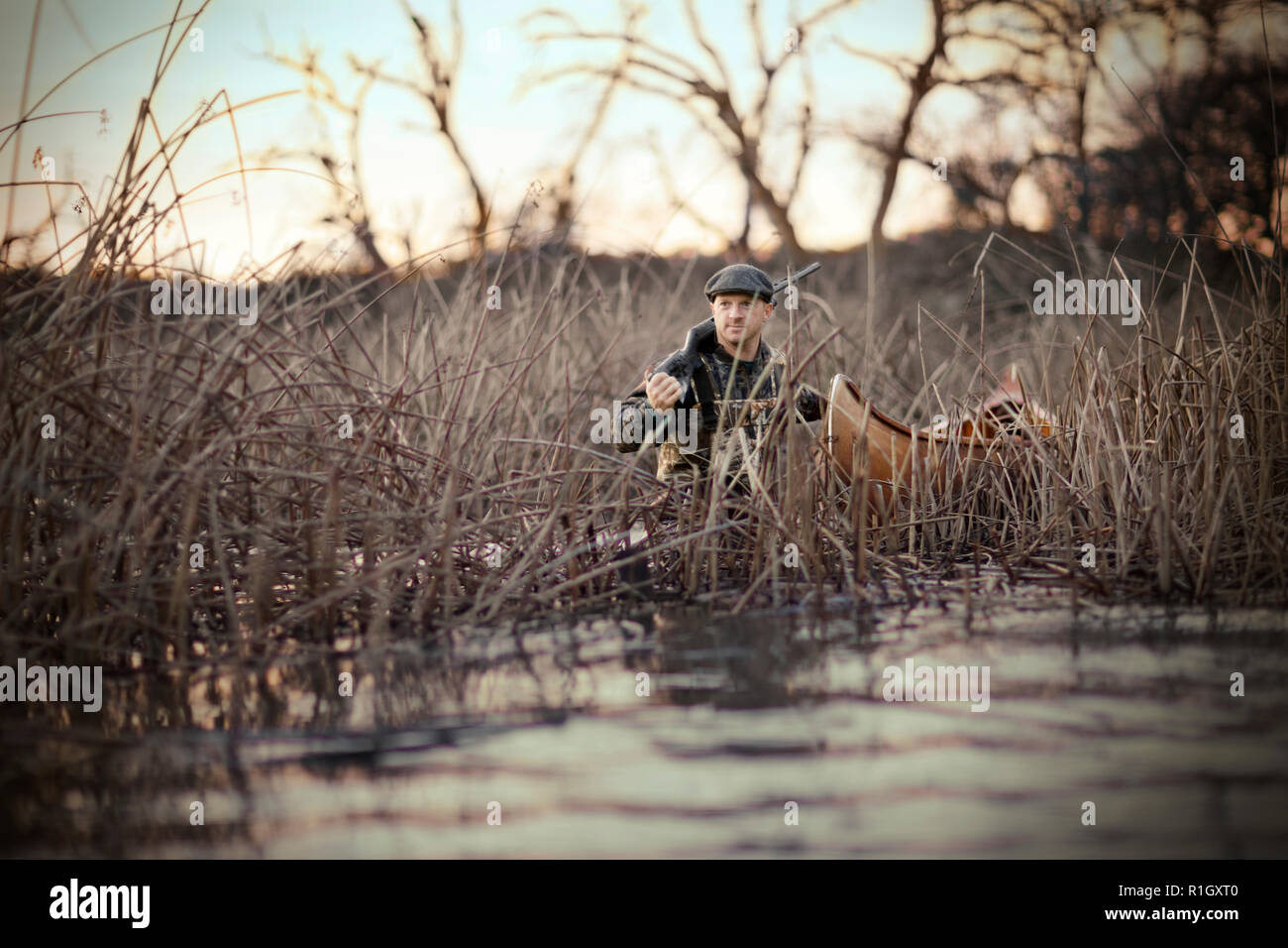 Young adult man duck shooting with a gun and a canoe in a lake Stock ...