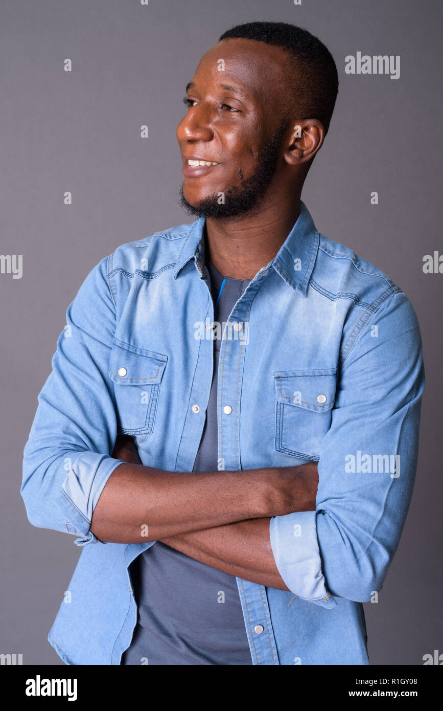 Young handsome African man with short hair against gray backgrou Stock ...