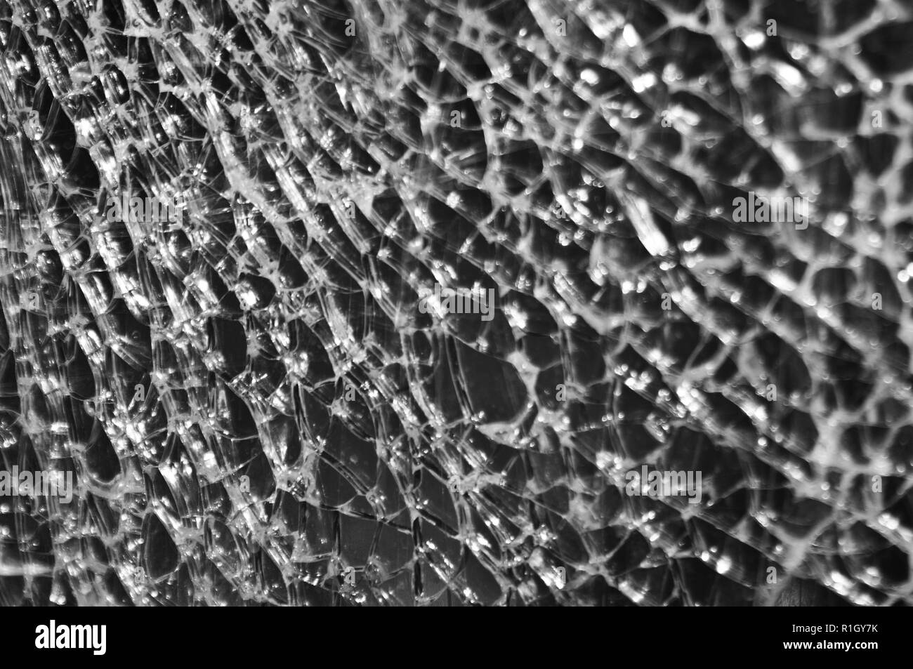 Black-and-white Texture of broken glass on dark background. Closeup ...