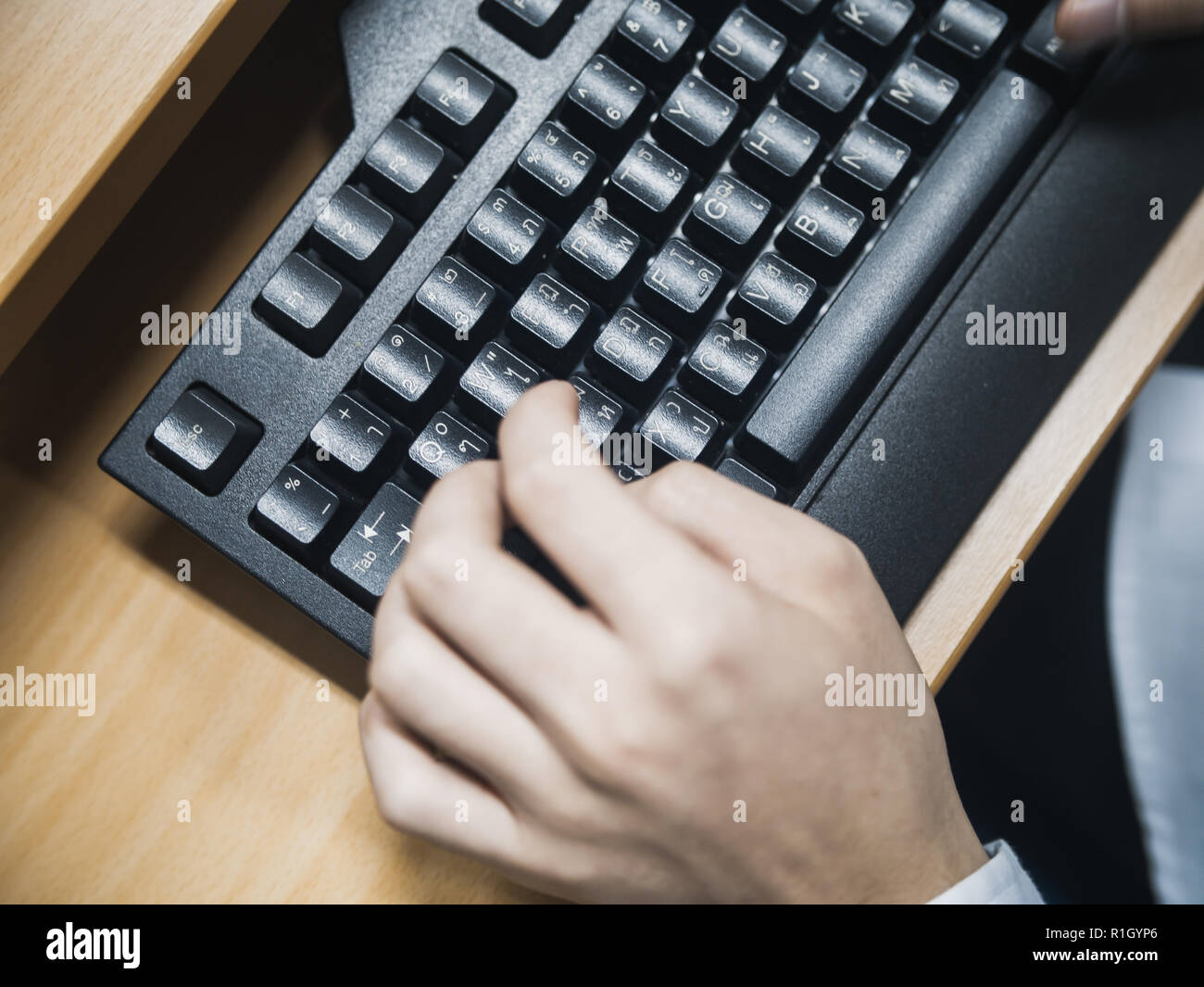 Male student typing his work using the keyboard, which was placed on ...