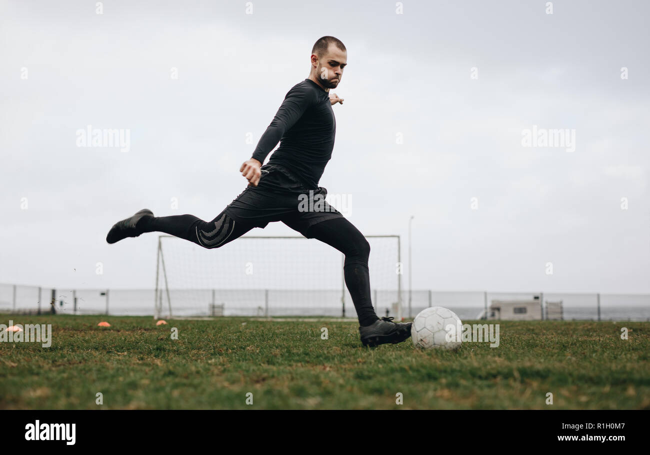 Soccer player kicking ball on field hi-res stock photography and images ...