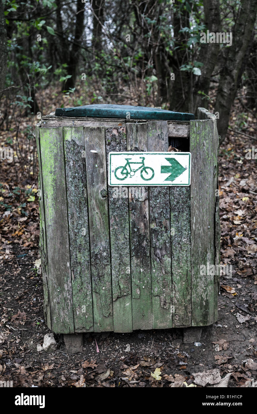 Green cycle path sign and arrow fixed to an old wooden algal covered ...