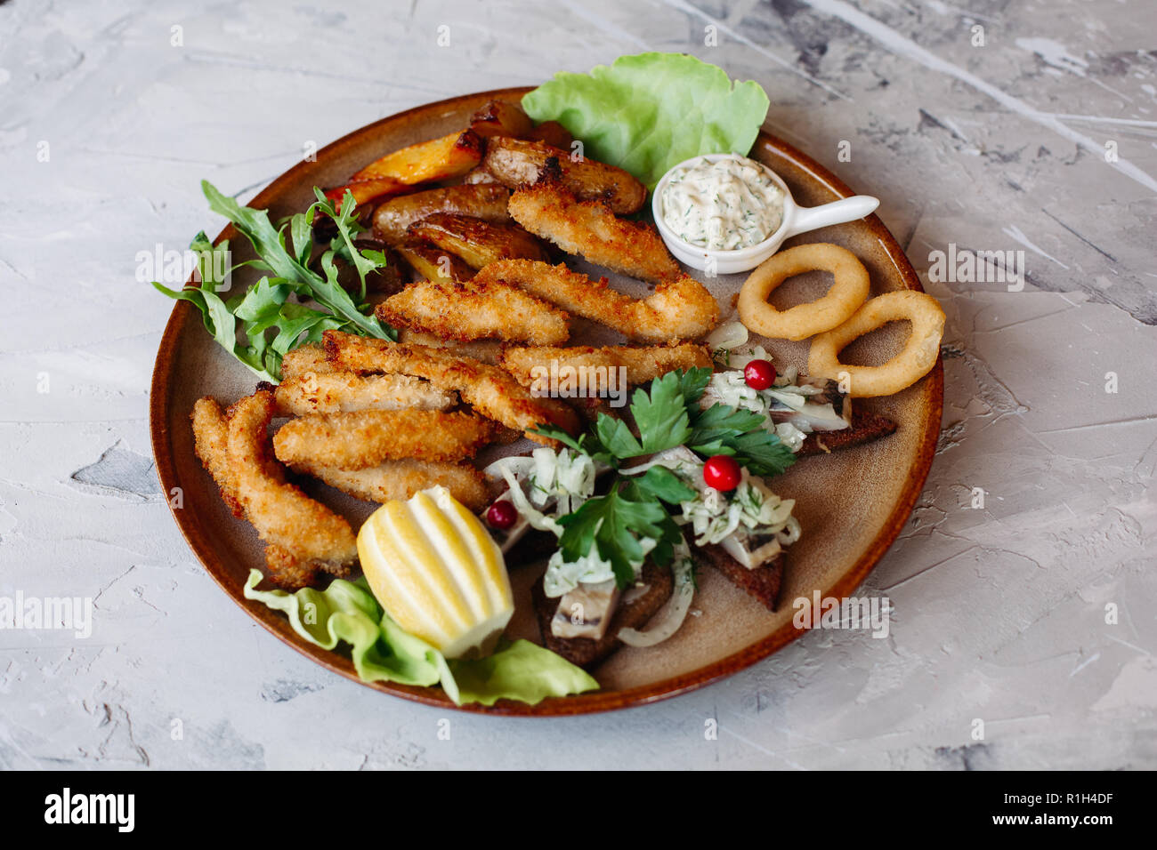Clay plate full of delicious appetizers.garlic sauce, decorated with ...