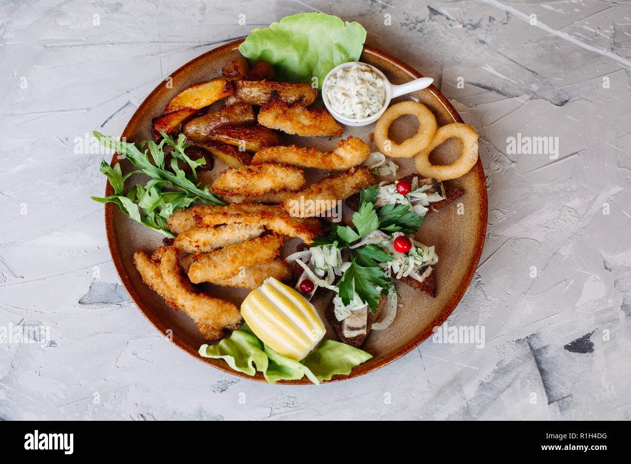Clay plate full of delicious appetizers.garlic sauce, decorated with ...