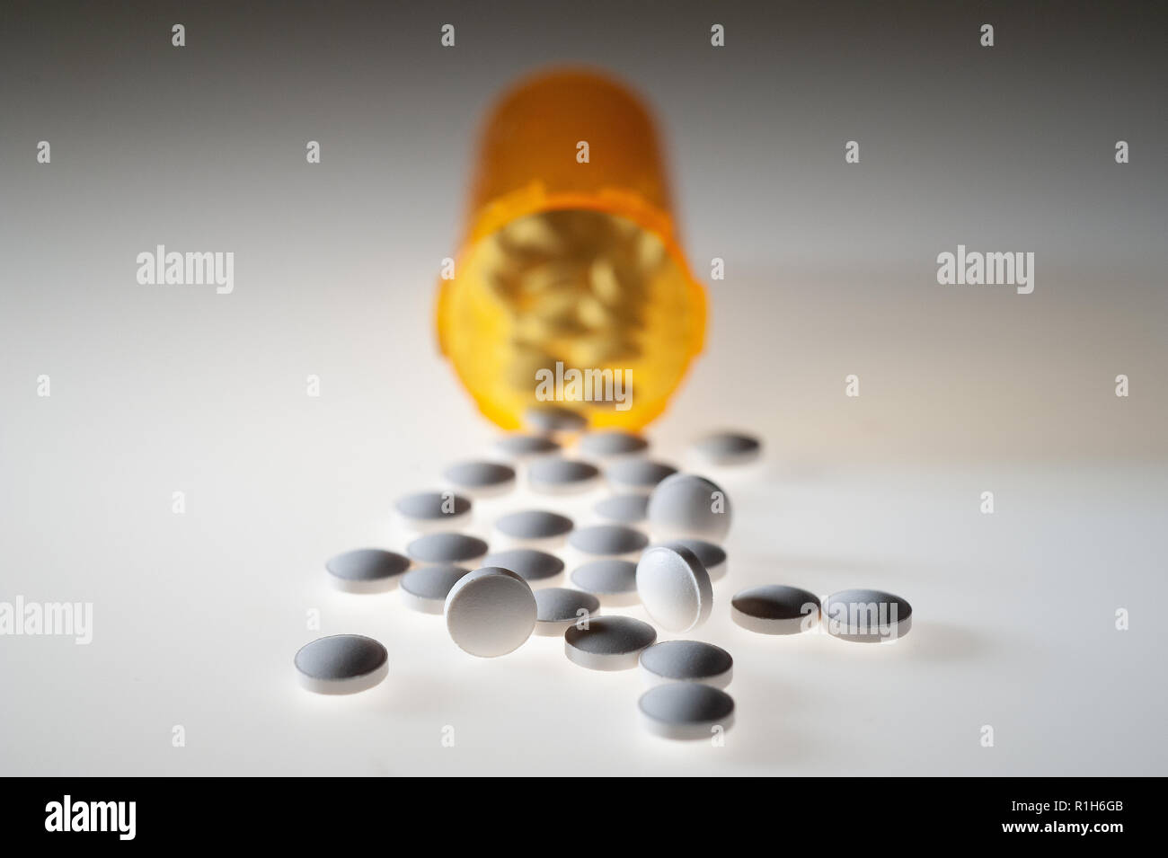 Medication pills pouring out of orange plastic bottle Stock Photo - Alamy