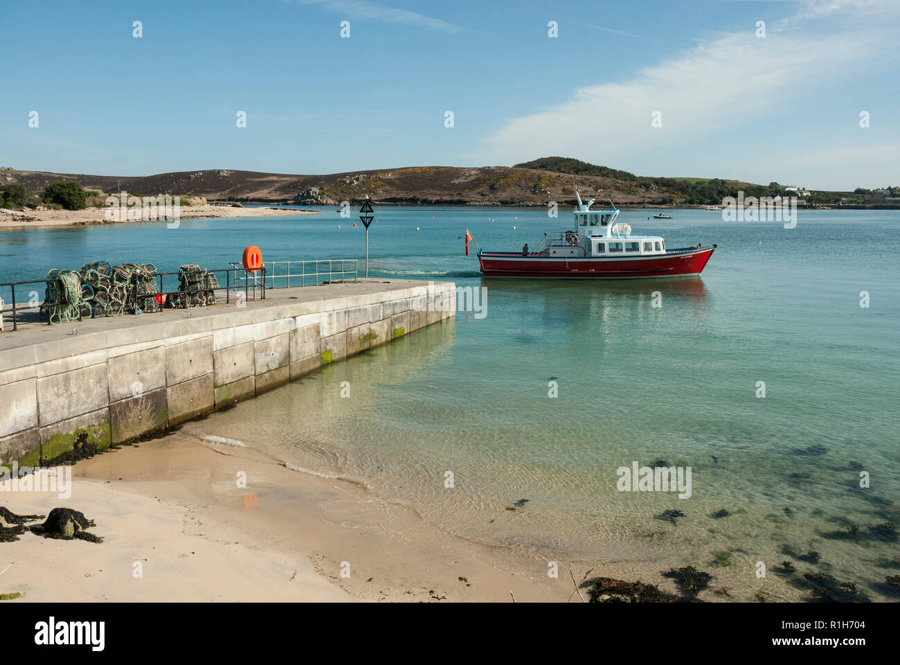 A ferry leaving Church Quay jetty, Bryher, on a beautiful sunny day ...