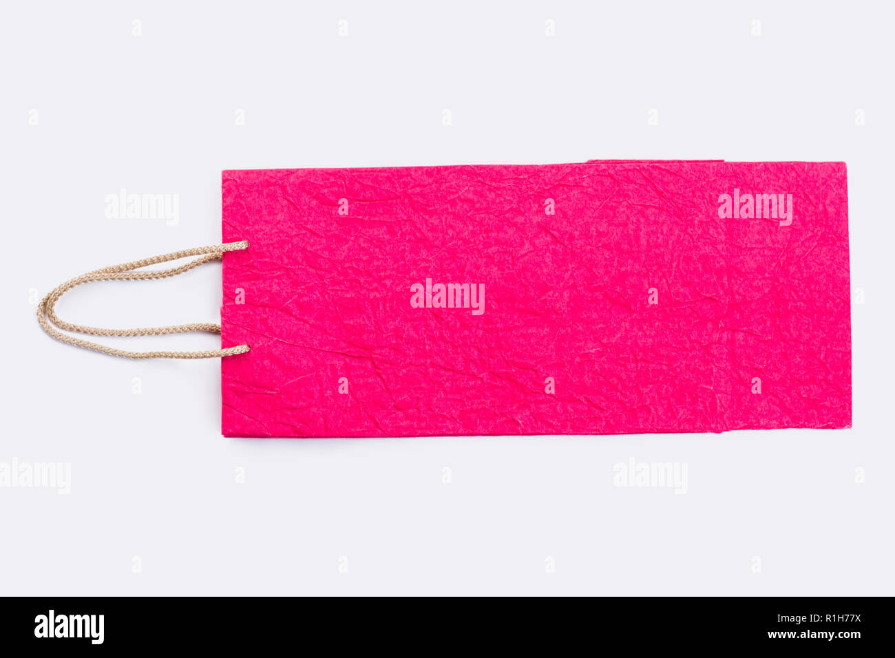 Pink paper shopping bag with rope handles Stock Photo - Alamy