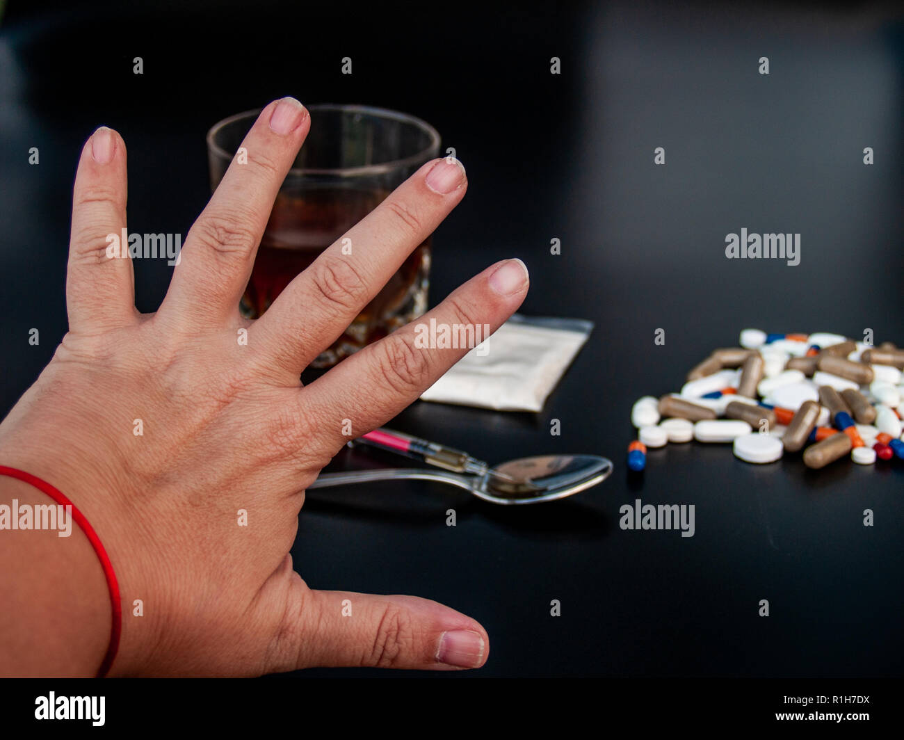 A person gesturing with his hand stop drugs, Pills of different sizes ...