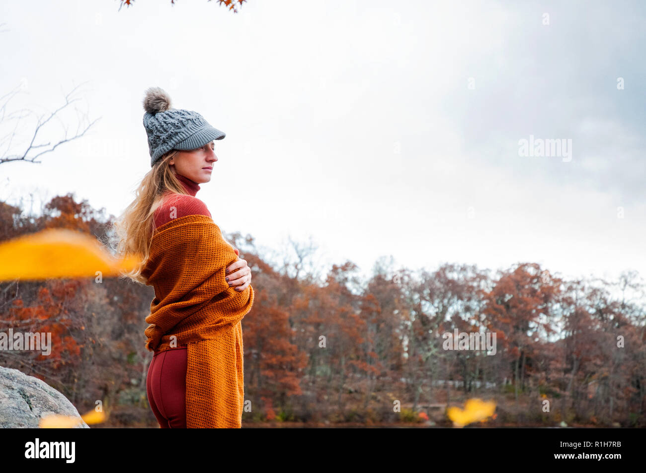 Woman traveler in warm hat and autumn clothes looking at amazing lake ...