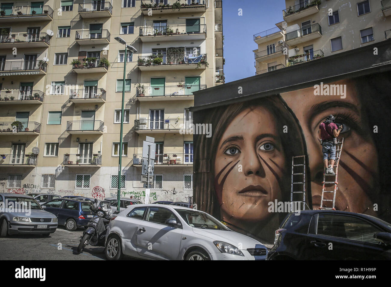 Street artist Jorit works on a mural depicting Ilaria Cucchi in the ...