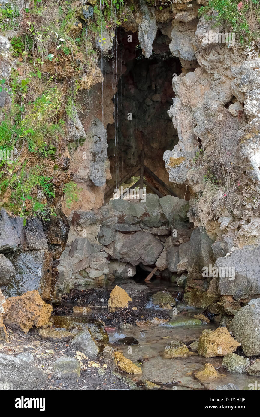 little grotto in the forest with water water that seeps between the ...