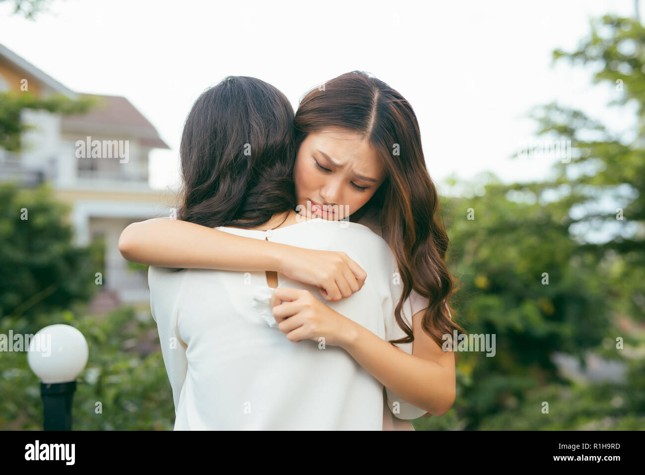 Two women hugging sad hi-res stock photography and images - Alamy