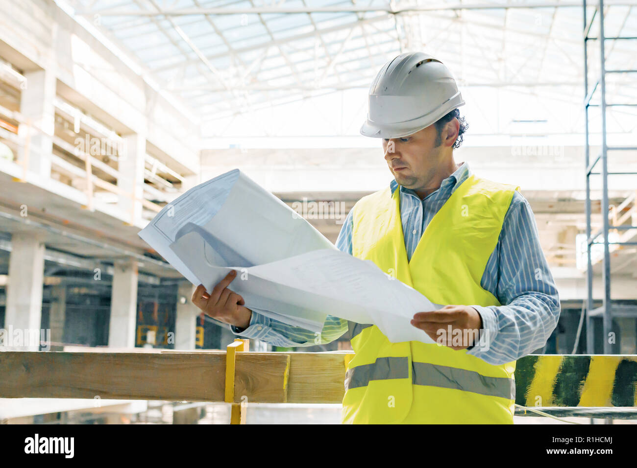Portrait of male engineer at construction site. Builder looks at the ...