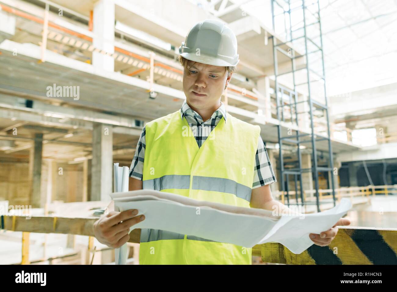 Portrait of male engineer at construction site. Builder looks at the ...