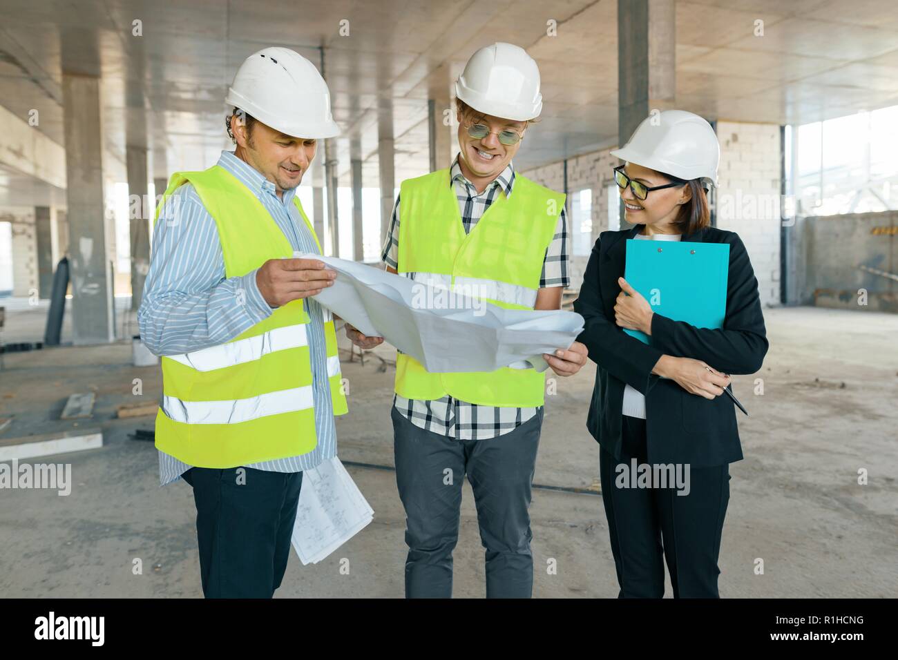 Group of engineers, builders, architects on the building site ...