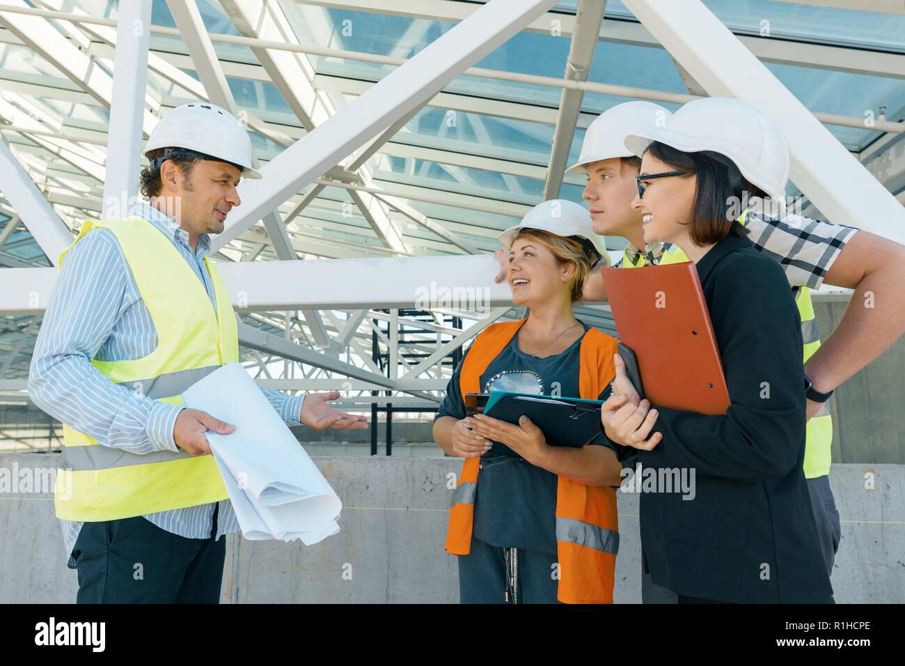 Group of engineers, builders, architects on the building site ...