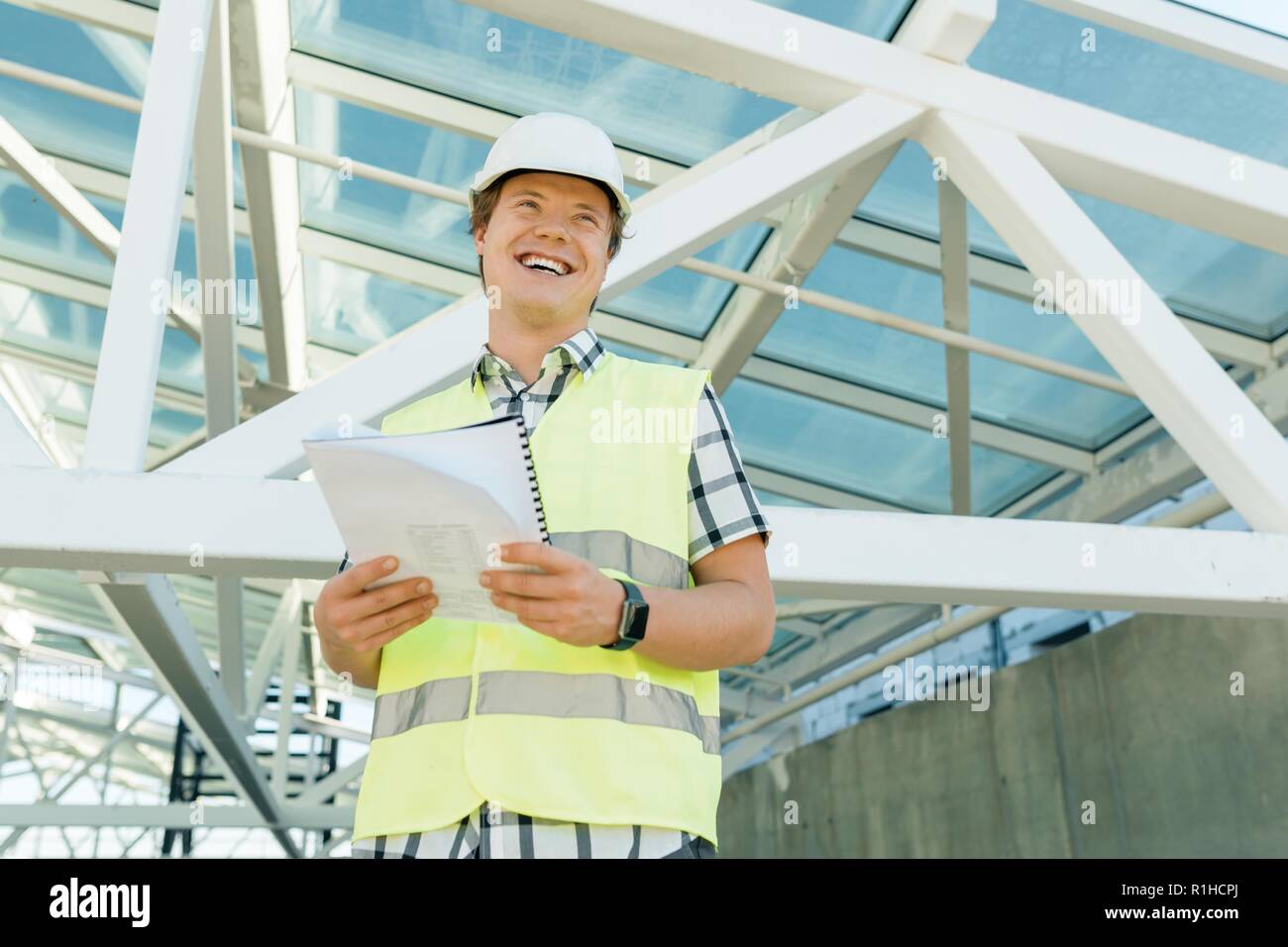 Portrait of male engineer at construction site. Builder looks at the ...