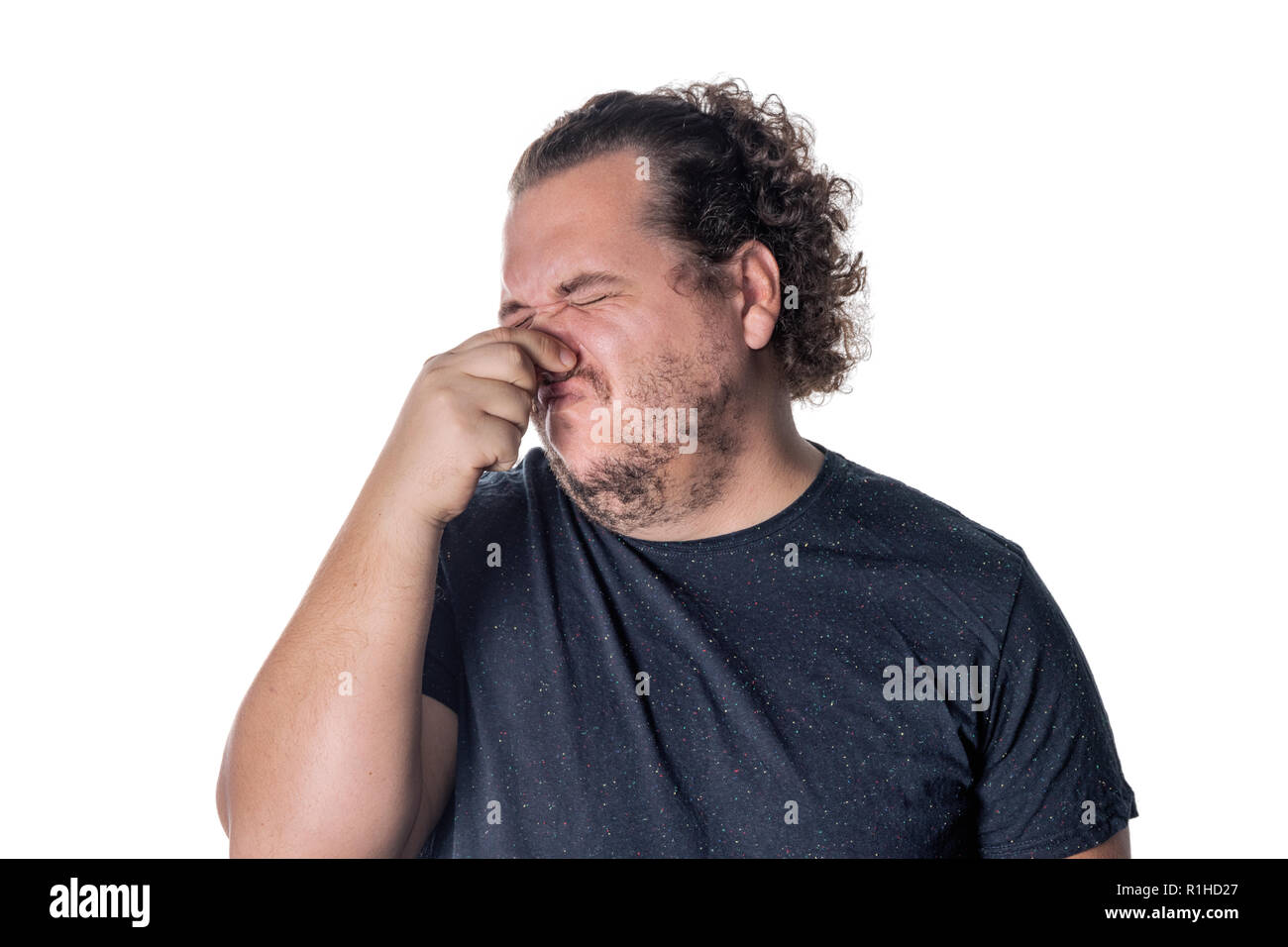 A young man holds or pinches his nose shut because of a stinky smell or ...