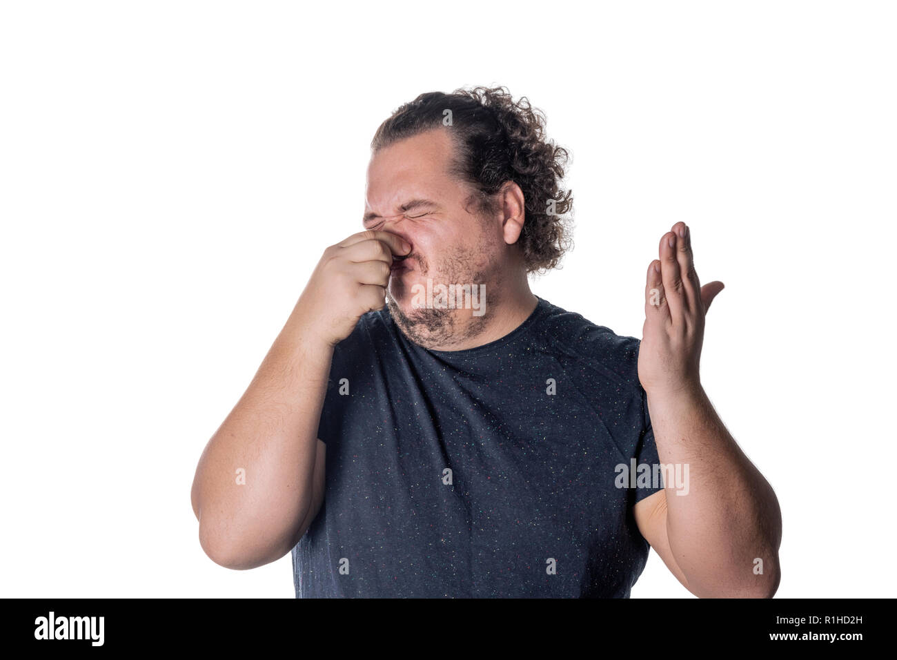 A young man holds or pinches his nose shut because of a stinky smell or ...