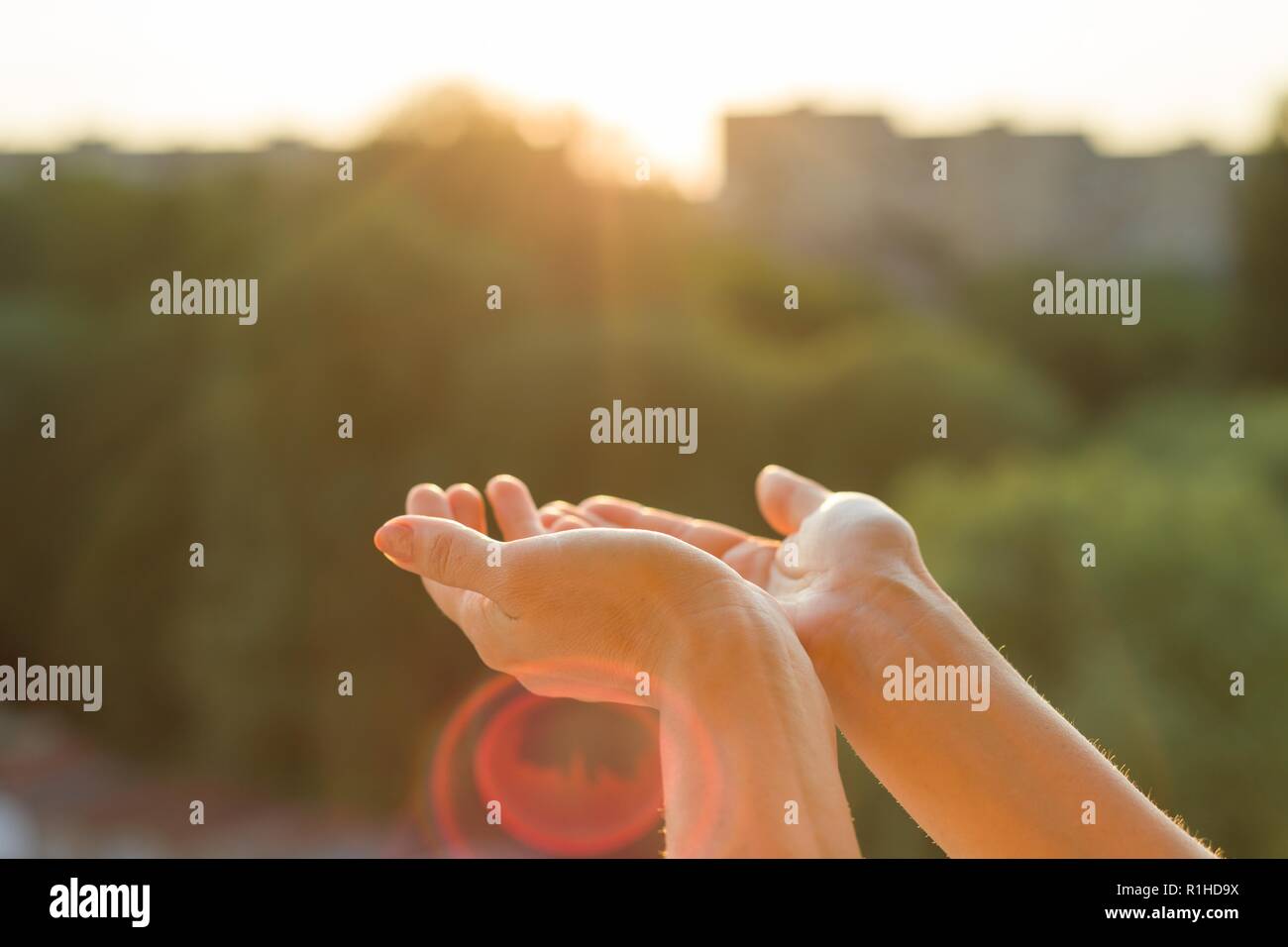 Hands open to the sunset, meditation, the background of the open window ...