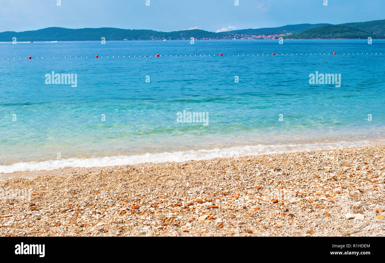 Pebble sandy beach on the background of a hill range with many small ...