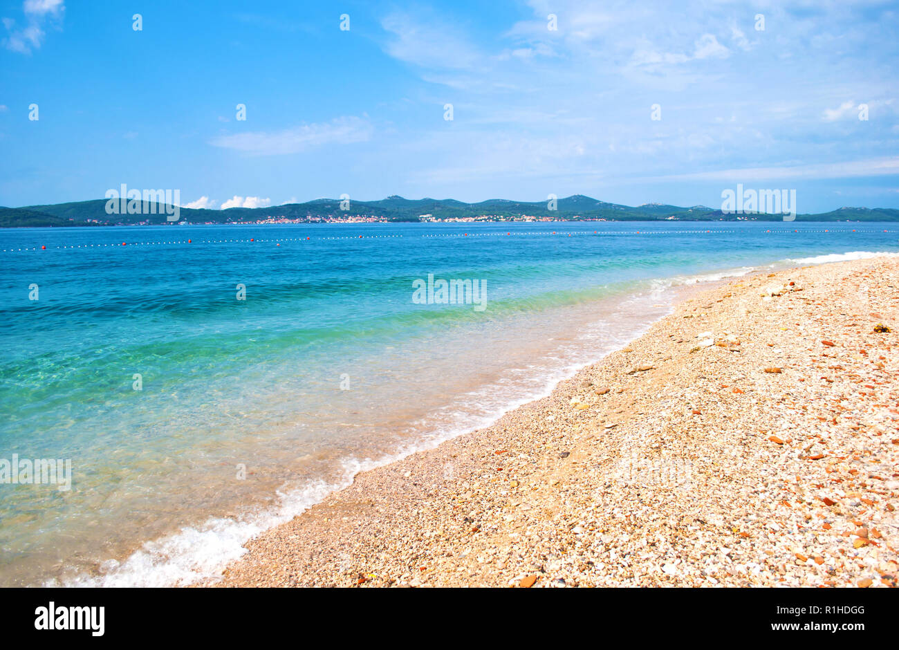 Pebble sandy beach on the background of a hill range with many small ...