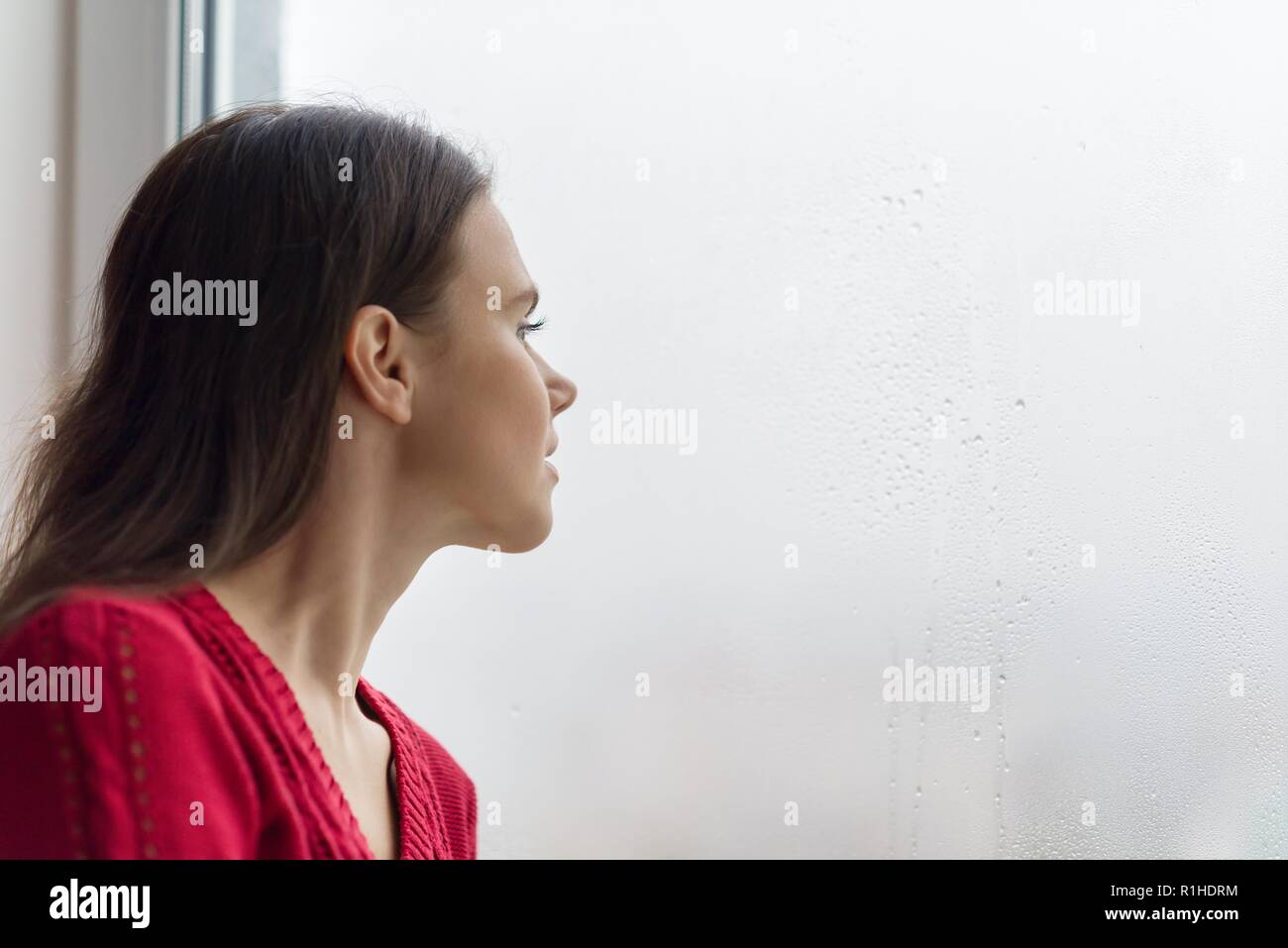 Girl looking out window sad rain hi-res stock photography and images ...