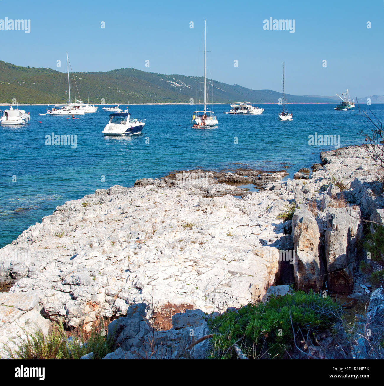 azure blue water of the lagoon, many yachts in the sea; hills covered ...