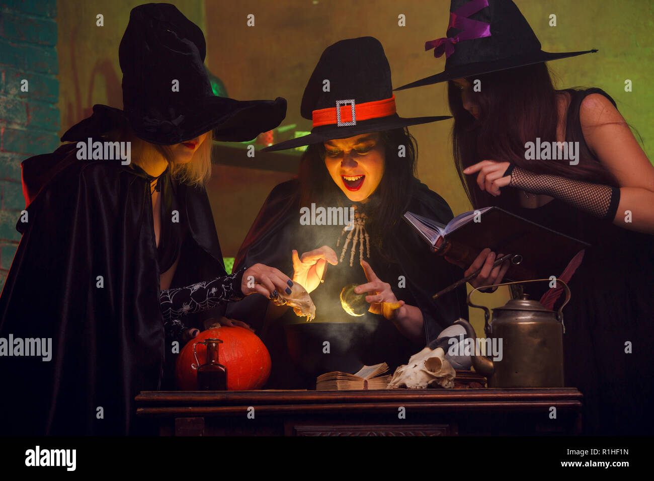 Picture of three witches in hats with book of potions making potions in ...