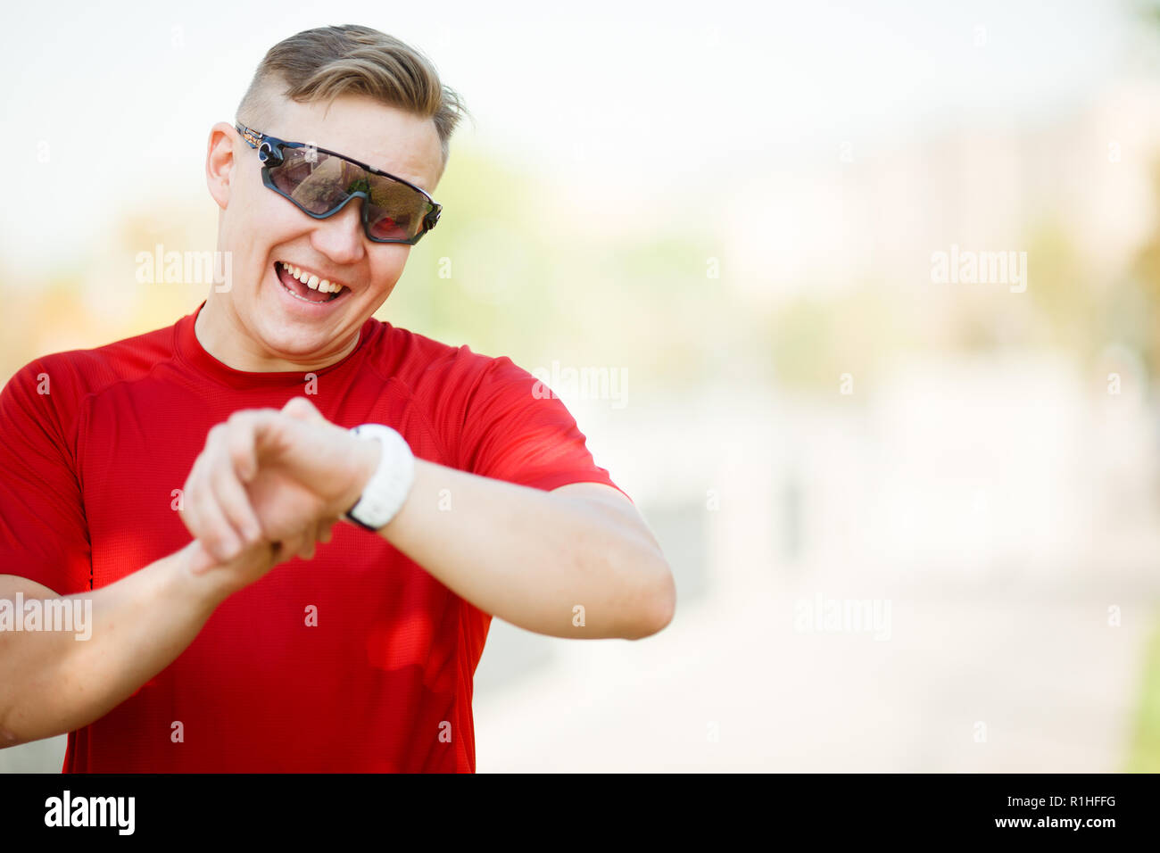 Photo of sport man looking at watch on blurred background Stock Photo ...