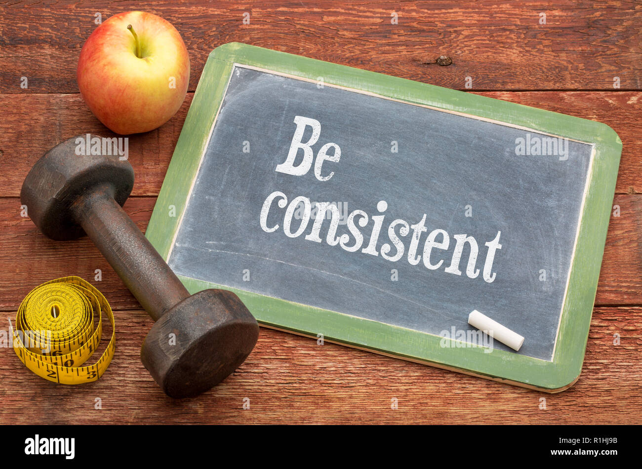Be consistent concept - slate blackboard sign against weathered red ...