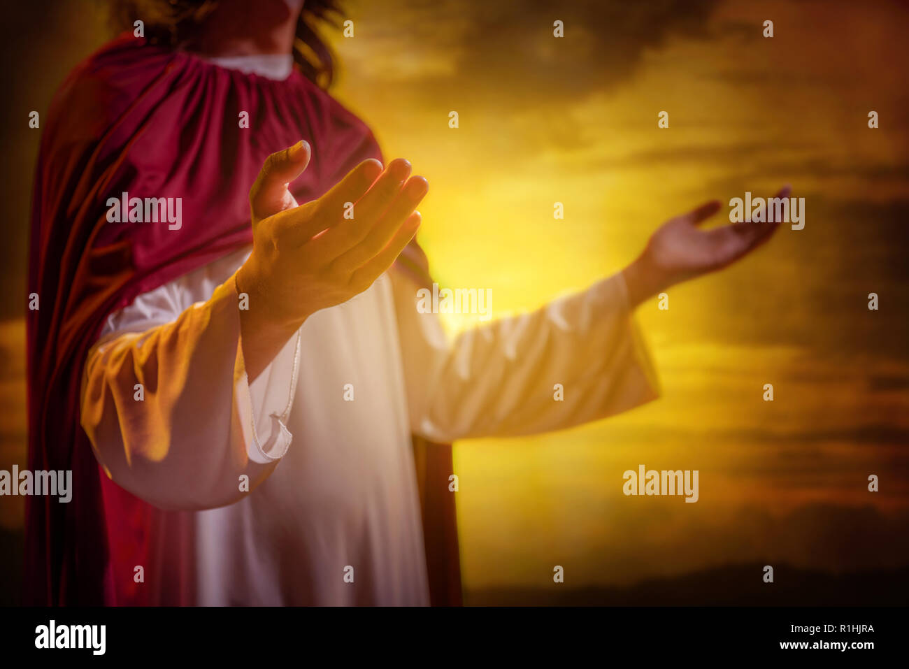 Jesus christ raising hands and praying with sunset background Stock ...