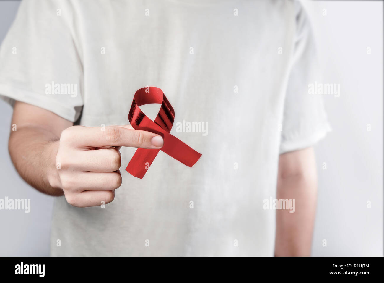 Man holding red ribbon Hiv Aids. World Aids day Stock Photo - Alamy