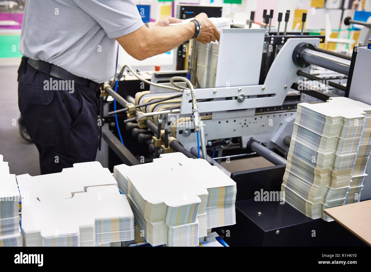 Worker at the conveyor of the machine for packing Stock Photo - Alamy
