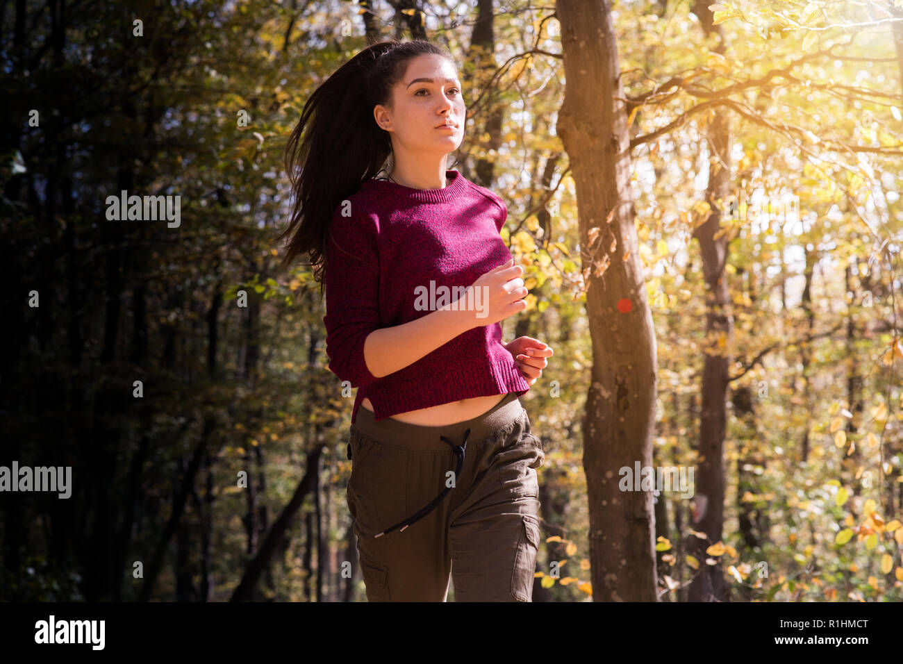 Beautiful girl running trough forest in autumn Stock Photo - Alamy