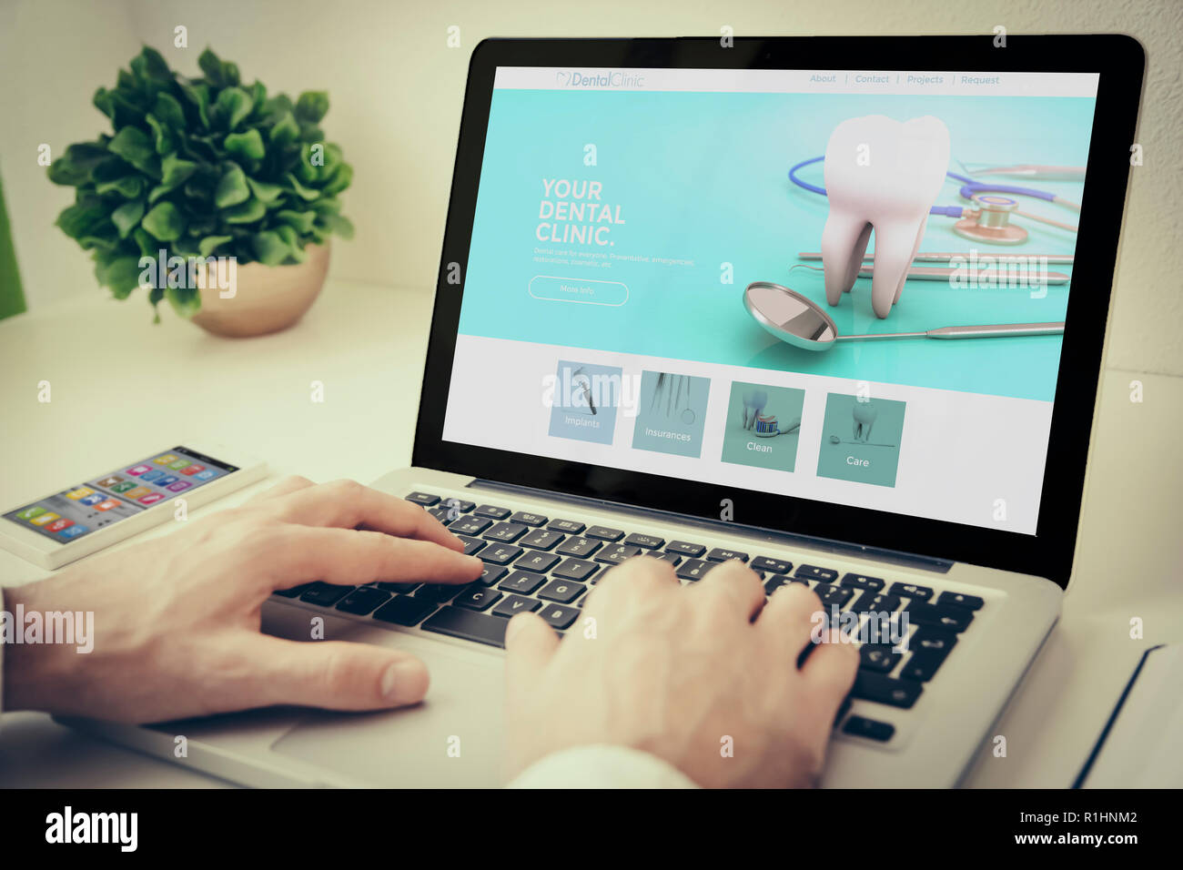 Hands using laptop on desktop with dental clinic Stock Photo - Alamy