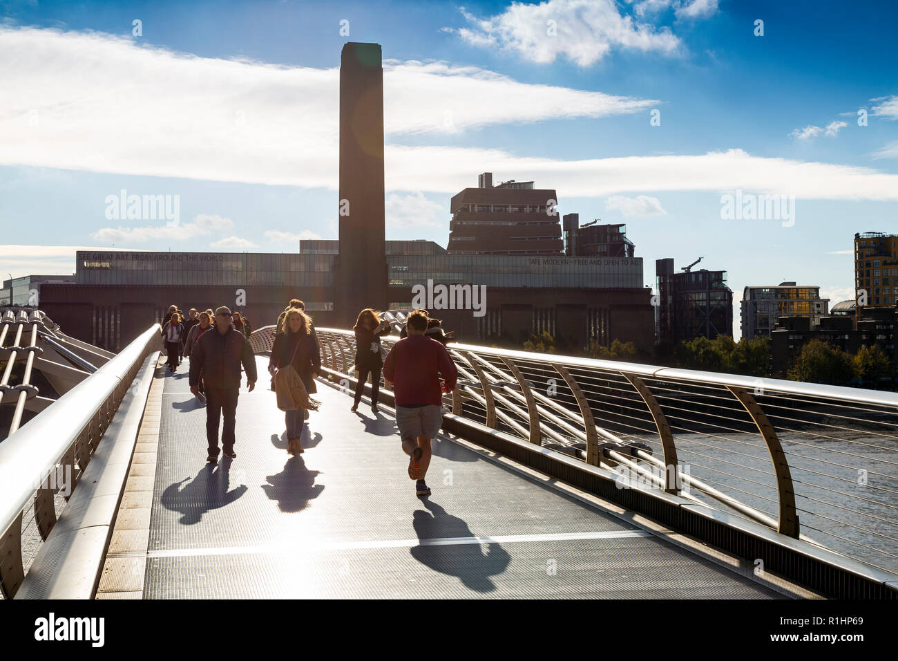 A man jogging and people walking over the Millennium Bridge (wobbly ...