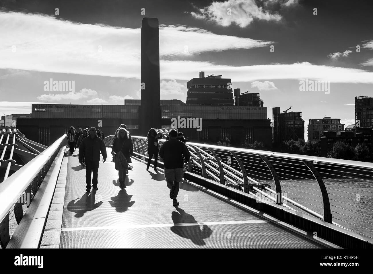 A man jogging and people walking over the Millennium Bridge (wobbly ...