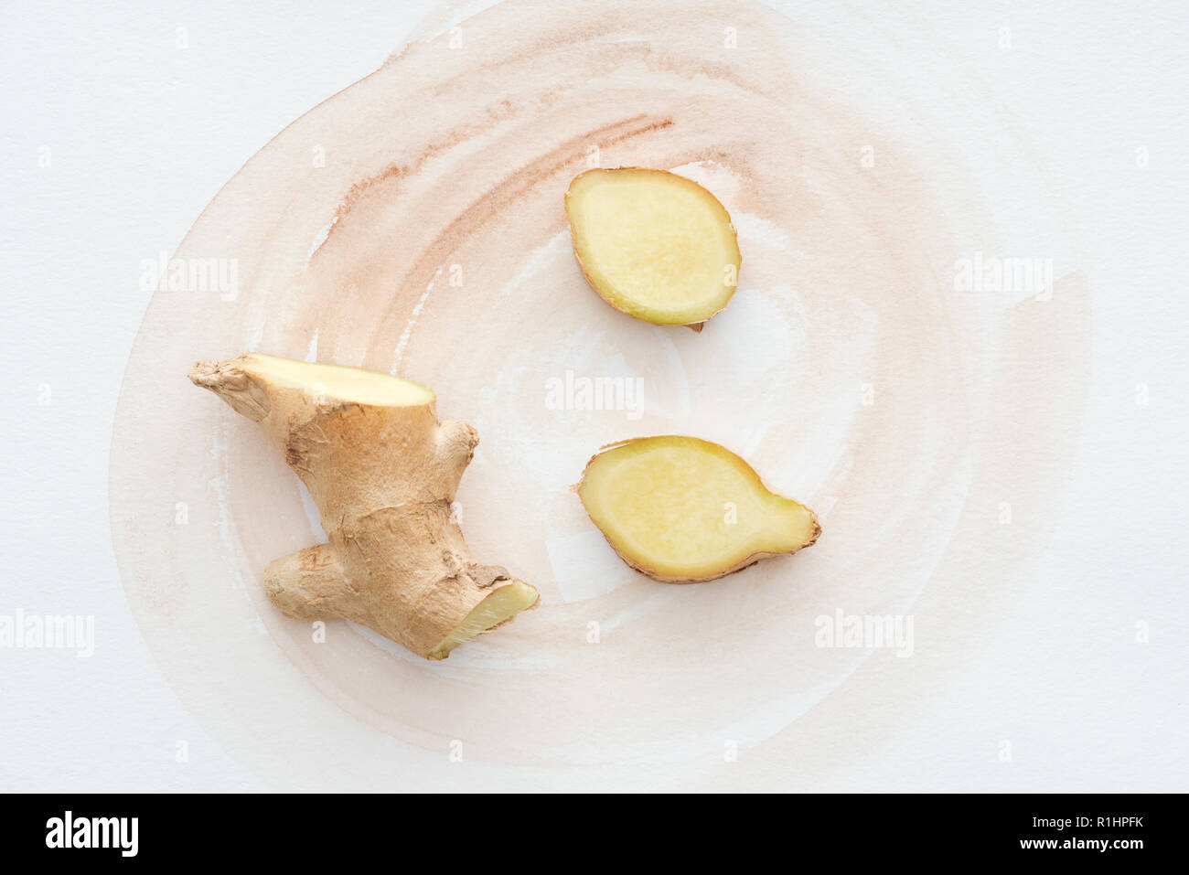 top view of sliced ginger root on white surface with watercolor strokes ...